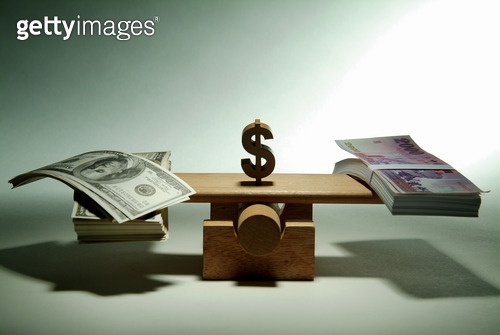 Close-up of dollar bills on a seesaw (a7331255) - 게티이미지뱅크