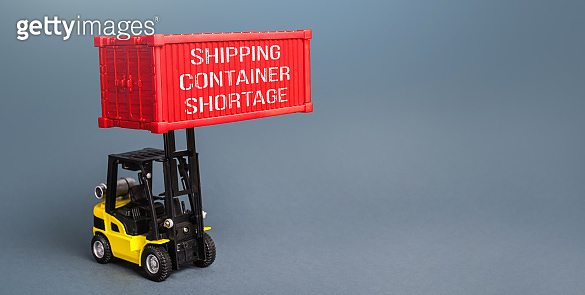 A forklift is loading a container. Container shortage. Inability to export and import products ...
