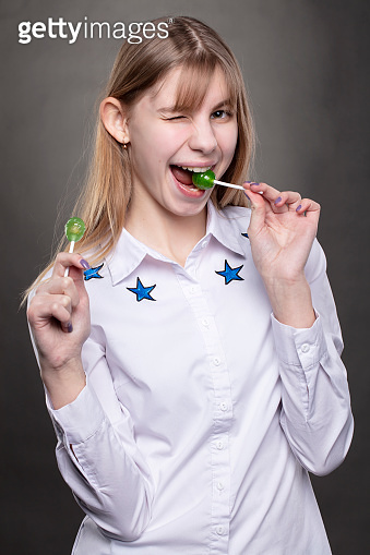 A Funny And Naughty Teenager Girl With A Lollipop Fooling Around At The