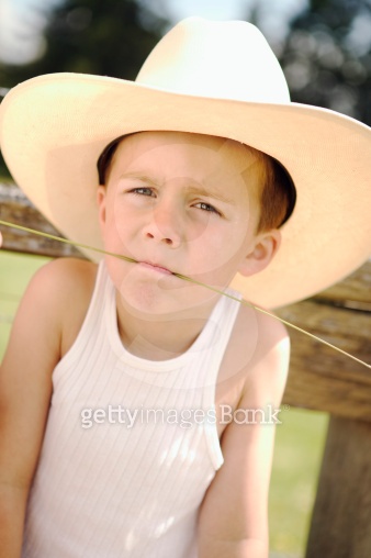 Boy wearing a cowboy hat and chewing on grass 이미지 (76649111) - 게티이미지뱅크