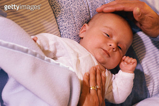 Parents' hands caressing baby who is lying in bed 이미지 (BAB_007) - 게티이미지뱅크
