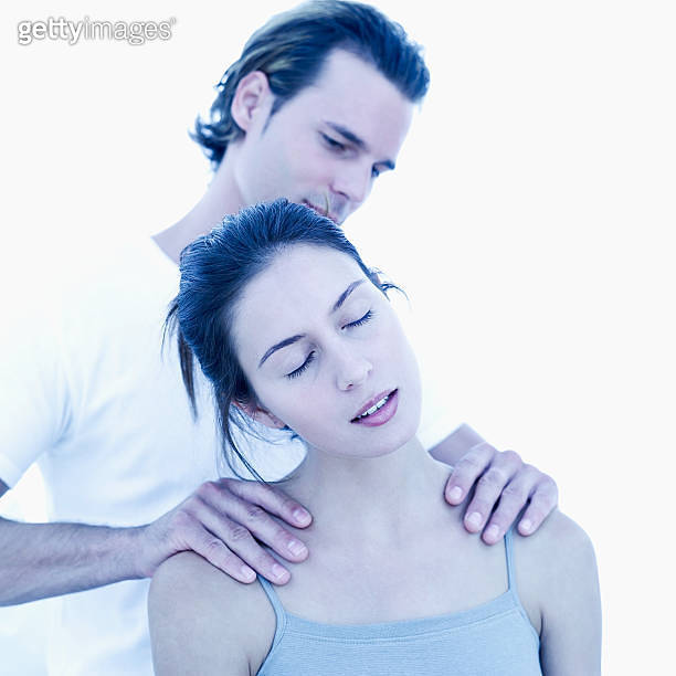 Young man giving a young woman a shoulder rub 이미지 (57304262) - 게티이미지뱅크