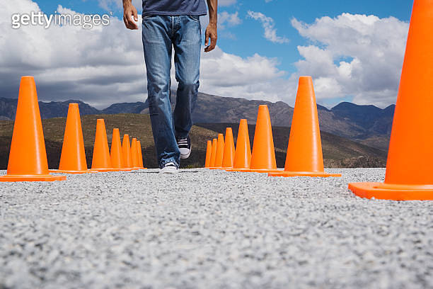 Man walking in-between two rows of safety cones 이미지 (75592846) - 게티이미지뱅크