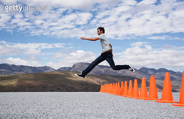 Man jumping over safety cones 이미지 (75592831) - 게티이미지뱅크