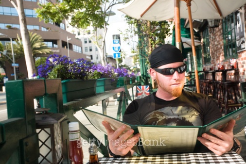 Man reading menu on terrace of restaurant, Santa Monica, California ...