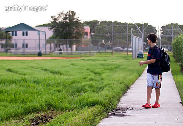 Young boy looking back over his shoulder at school 이미지 (114244100) - 게티 ...