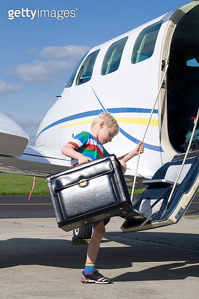 Child climbing the steps of a light aircraft with case 이미지 (471111443) - 게티이미지뱅크