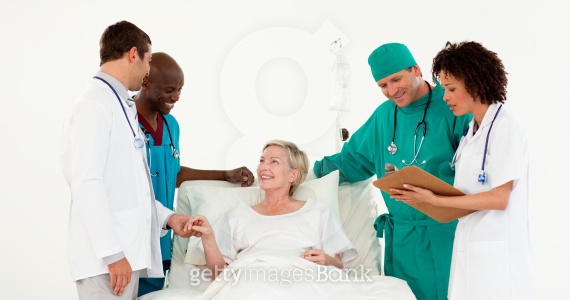 Team of doctors looking after a sick senior patient (125160849) - 게티이미지뱅크