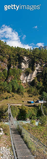 Rope bridge ravine Himalayas Everest trail valley vertical panorama ...