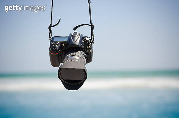 DSLR camera hanging at the beach scenery 이미지 (171306931) - 게티이미지뱅크