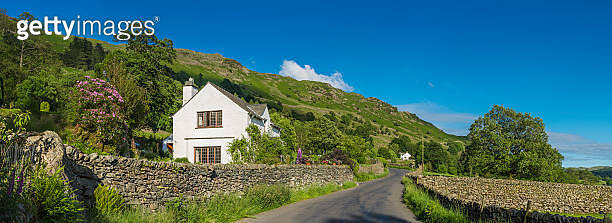 Pretty cottage country garden beside lane and green hills 이미지 ...