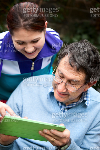 adults happily using an IPad together 이미지 (459003603) - 게티이미지뱅크