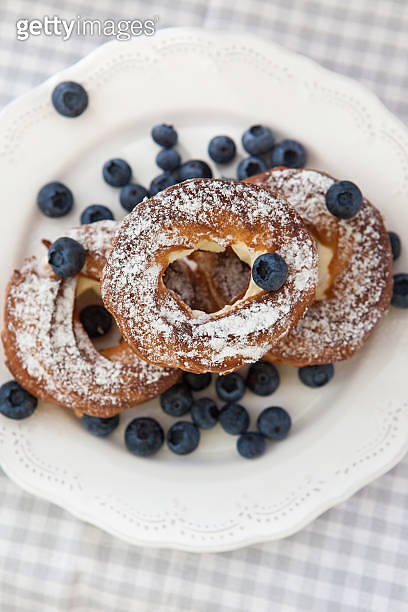 Cream puffs or choux pastry rings with blueberries on plate 이미지 ...