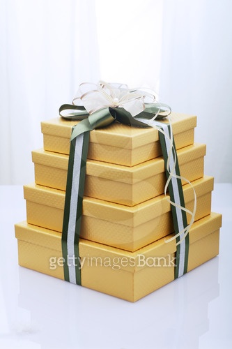 Stack of four yellow gift boxes tied together with ribbon, close-up 이미지 (a4001880) - 게티이미지뱅크