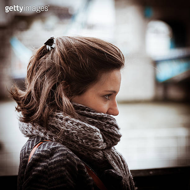 woman in profile with scarf on a windy day (453812931) - 게티이미지뱅크