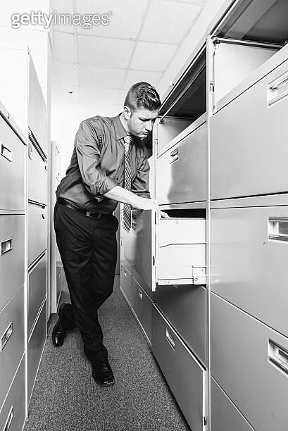 Business person searching in filing cabinets 이미지 (181131457) - 게티이미지뱅크