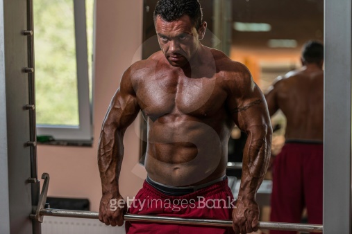 male bodybuilder doing heavy weight exercise for trap (180886818) - 게티이미지뱅크