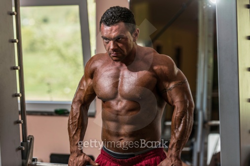 male bodybuilder doing heavy weight exercise for trap (180889140) - 게티이미지뱅크