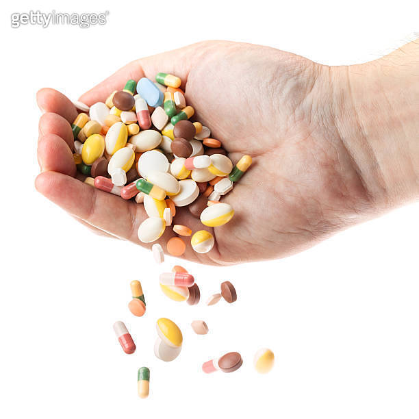 Man's hand holding and dropping a handful of medicine pills 이미지 ...