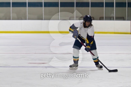 Female ice hockey player shooting the puck during a game (466816659 ...