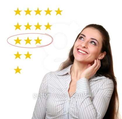Woman looking up and choosing average stars rating (484102141) - 게티이미지뱅크