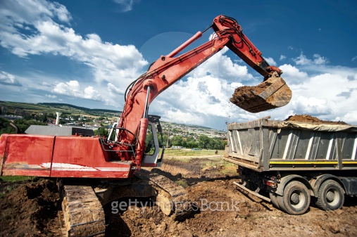 Industrial excavator loading soil material from highway construction ...