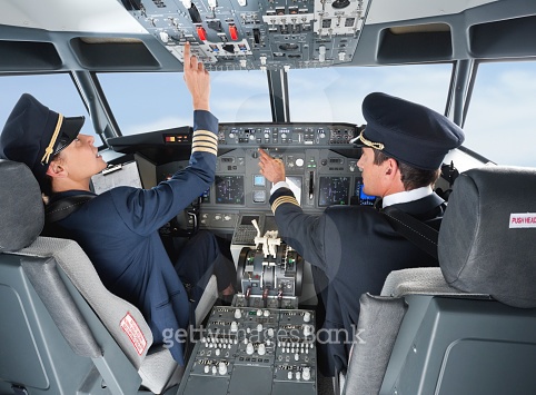 Pilot pushing button in airplane cockpit with co-pilot 이미지 (528955815 ...
