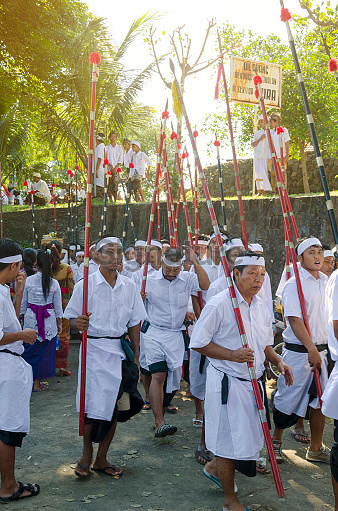 Pilgrims and male temple dancer walking to temple in Bali (475763160 ...