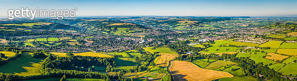 Aerial panorama over country town green fields Stroud Valley England ...