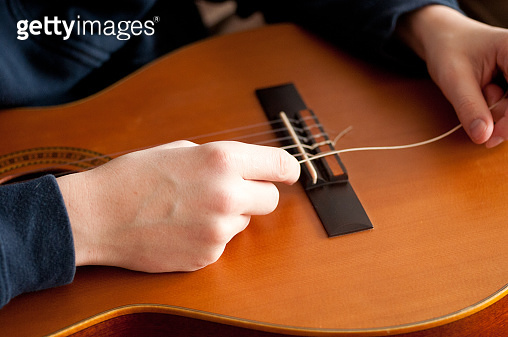 boy strings a guitar 이미지 (466328936) - 게티이미지뱅크