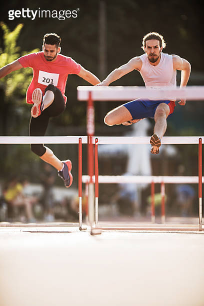 Two athletic men competing on a hurdle race. 이미지 (478477522) - 게티이미지뱅크