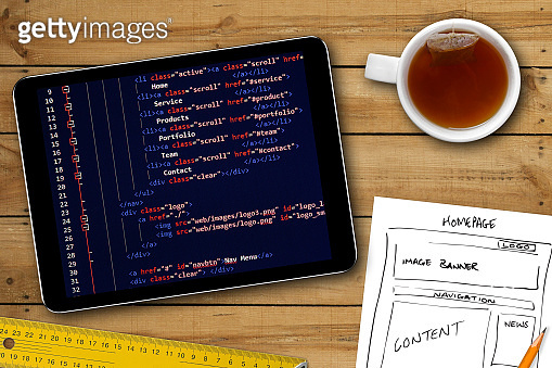 website wireframe sketch and programming code on digital tablet ...
