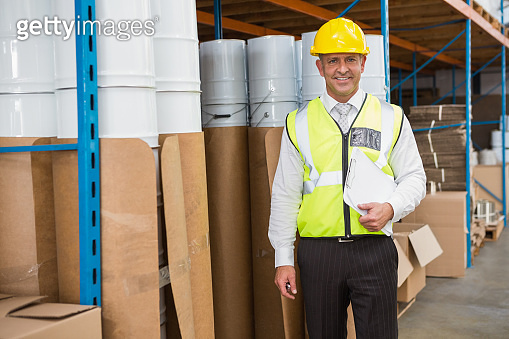 Warehouse manager wearing hard hat holding clipboard 이미지 (535479361 ...