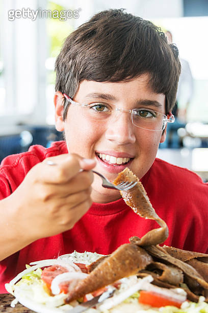 Teenage boy enjoying eating Greek food. 이미지 (537593999) - 게티이미지뱅크