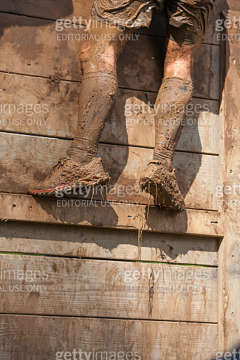 Muddy legs scaling a large wooden obstacle 이미지 (489143922) - 게티이미지뱅크