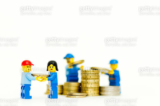 Group of Lego mini figure building a tower of coins. (485705880) 일러스트 ...
