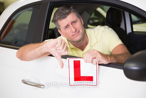 Man gesturing thumbs down holding a learner driver sign 이미지 (468680940 ...