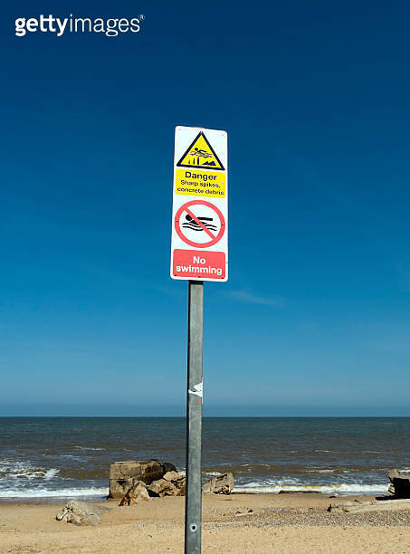 Dangerous structures with warning sign on a Suffolk beach 이미지 ...