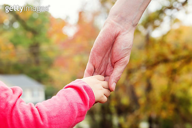 Toddler girl holding hands with her father on a fall (604370380) - 게티이미지뱅크