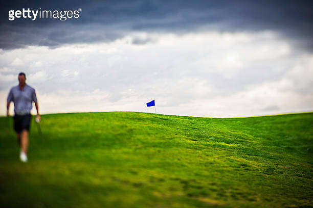 After the shot. Man leaving golf course after putting ball (598788042 ...
