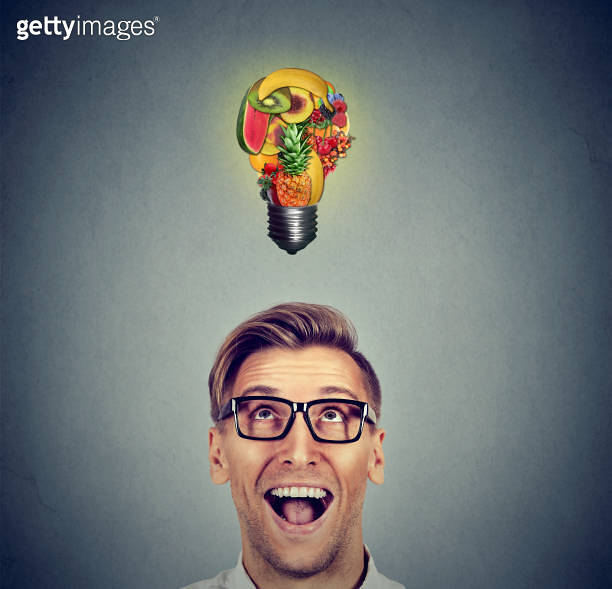 Eating healthy. Man looking up at fruit light bulb 이미지 (600687412) - 게티 ...