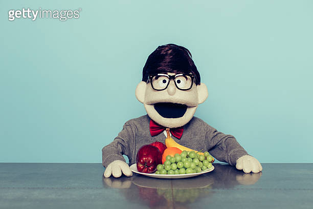 Nerd Puppet with Glasses Loves Eating Fruit (505850568) - 게티이미지뱅크