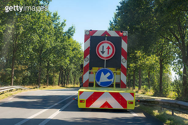 Driving behind roadwork vehicle over road with continuous lane lines ...