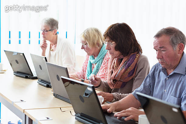 senior adults learning in computer lab (599675656) - 게티이미지뱅크