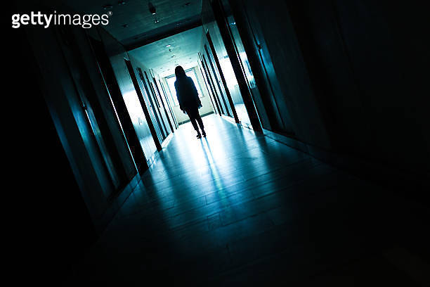 Young woman in dark building walkway 이미지 (612369296) - 게티이미지뱅크