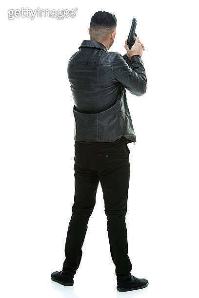 Rear view of man in action with gun 이미지 (623120546) - 게티이미지뱅크