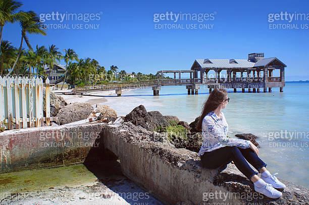 Girl look at Atlantic Ocean near old Key West pier (524387490) - 게티이미지뱅크