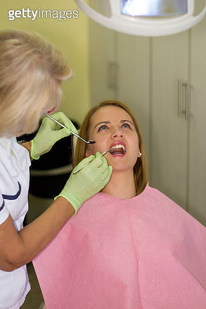 Woman baring her teeth for the dentist to inspect. 이미지 (596363760) - 게티 ...