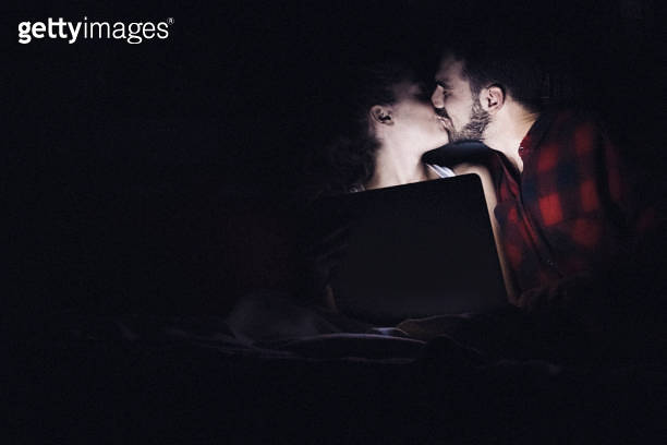 Young couple kissing behind a computer screen 이미지 (860973368) - 게티이미지뱅크