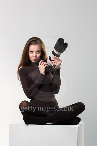 The beautiful photographer girl with professional dslr camera posing on ...